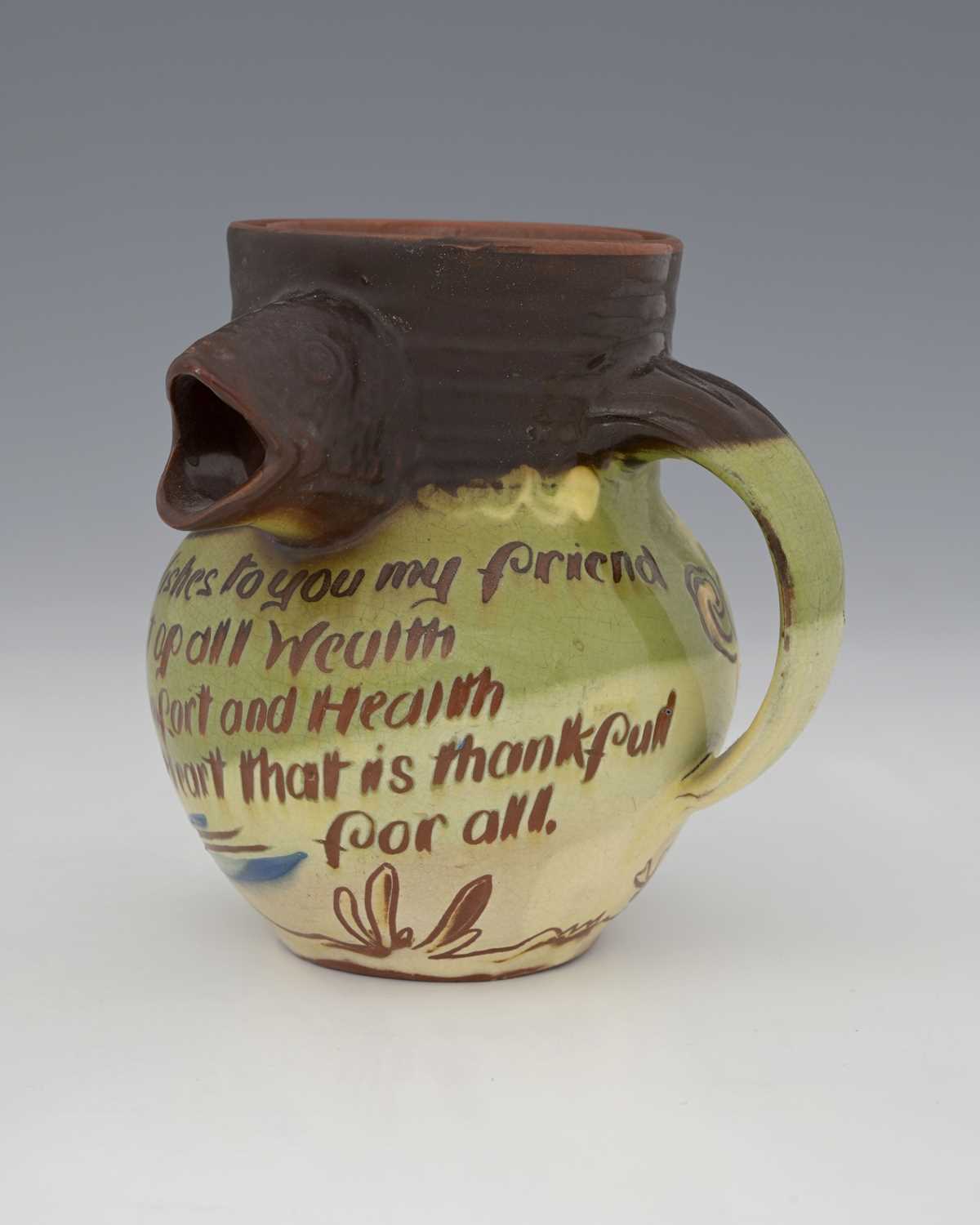 Lot 557 - C H Brannam, an art pottery fish motto jug,